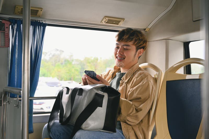 Happy Young Man Tourist Using a Smartphone in Public Transportation ...