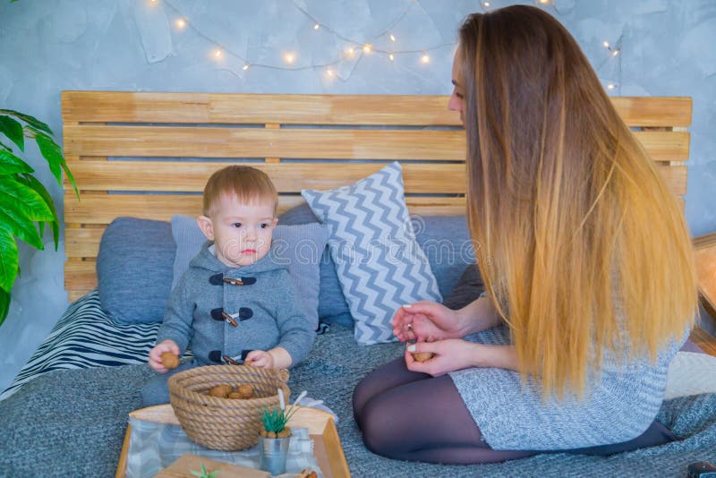 Happy Young Mother and Her Baby Son Playing with Walnuts Stock Photo ...