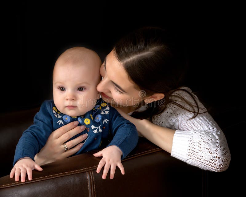 Happy Young Mother With Her Daughter On Her Hands On A Black Bac Stock