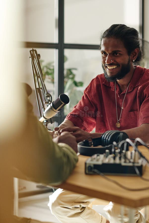Happy Young Multi-ethnic Man Looking at Guest Invited in Studio during ...
