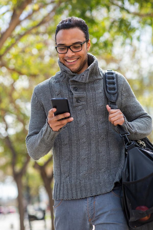 Happy Young Multi Race Guy Using Mobile Phone Carrying Bag Outside ...