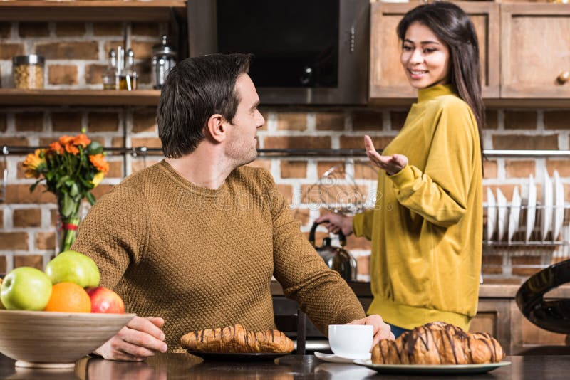 Happy Young Multiethnic Couple Smiling Each Other in Kitchen Stock ...