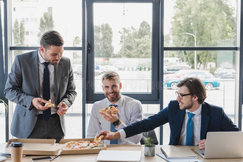 Happy Young Office Workers Eating Pizza at Workplace Stock Image ...