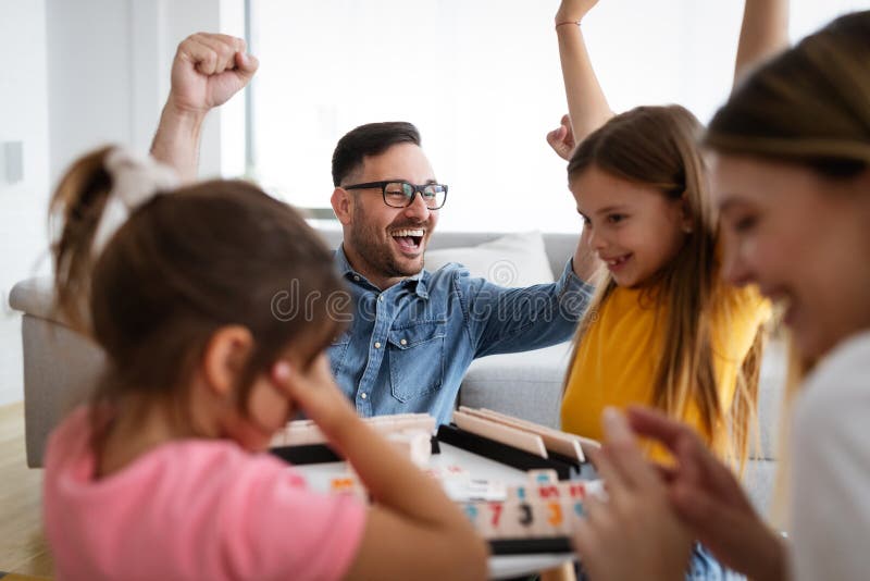 Happy Young Parents and Children Having Fun, Playing Board Game at Home ...