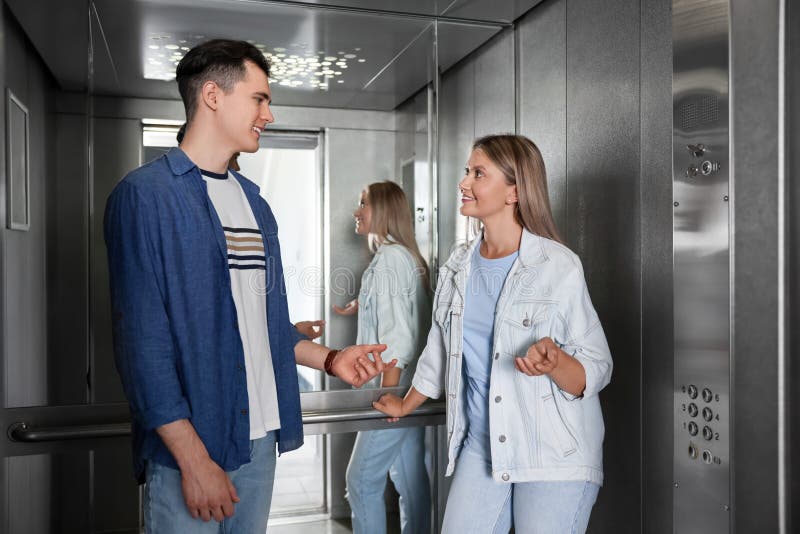 Happy Young People Talking in Modern Elevator Stock Photo - Image of adult, people: 258919336