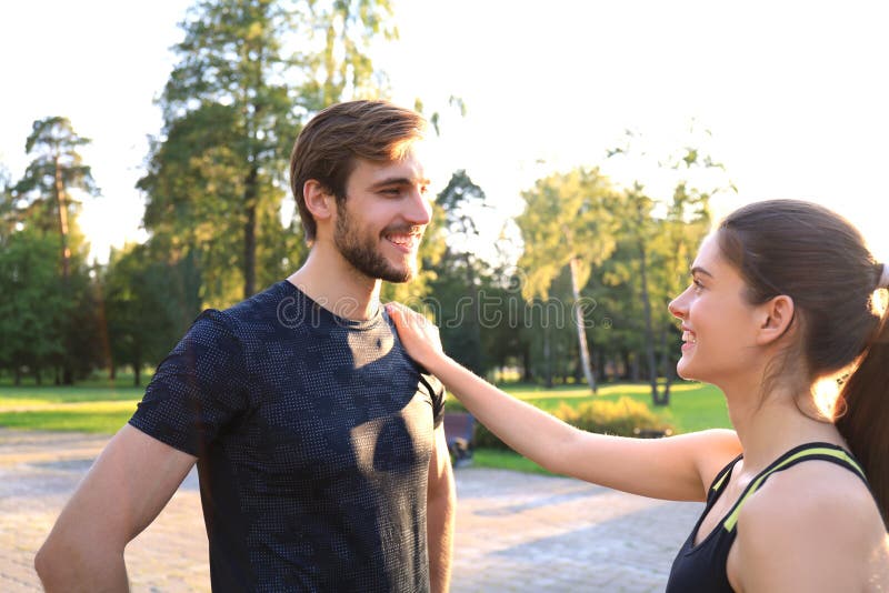 Happy Young Sport Couple Talking while Standing in Park Stock Image ...