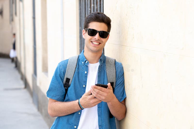 Happy Young Student Male Texting on His Smart Phone in Modern City ... Happy Young Student Male Texting on His Smart Phone in Modern City ...