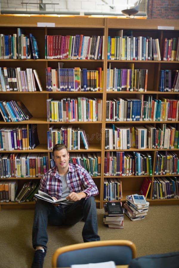 Happy Young Student Sitting on Library Floor Reading Stock Photo ...
