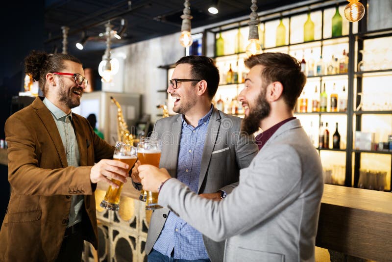 Happy Young Businessmen Drinking Beer and Talking at Pub after Work ...