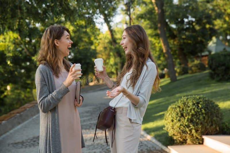 Happy Young Two Women Walking Outdoors in Park Drinking Coffee Stock ...
