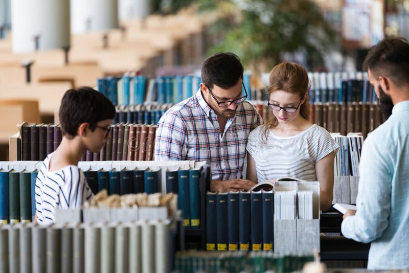Happy Young University Students Studying with Books in Library Stock ...