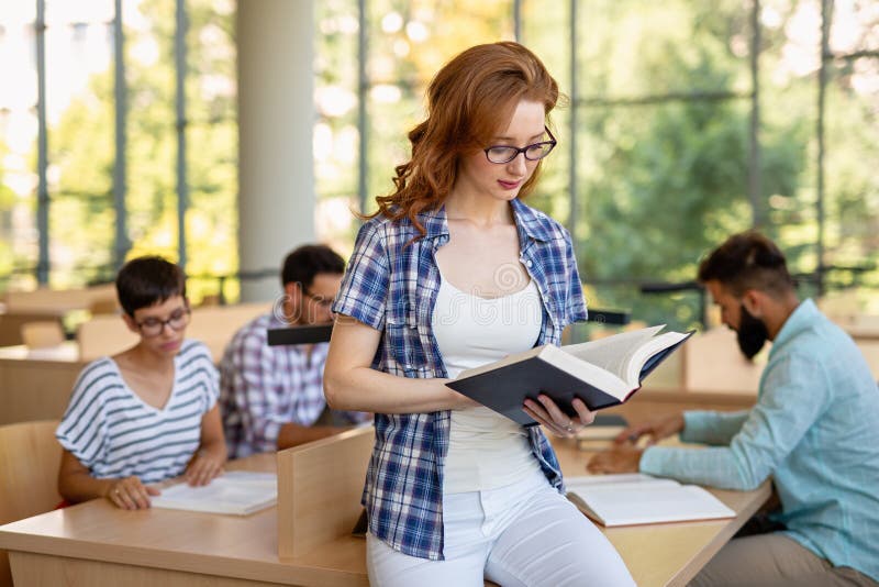 Happy University Students Studying with Books in Library. Group of ...