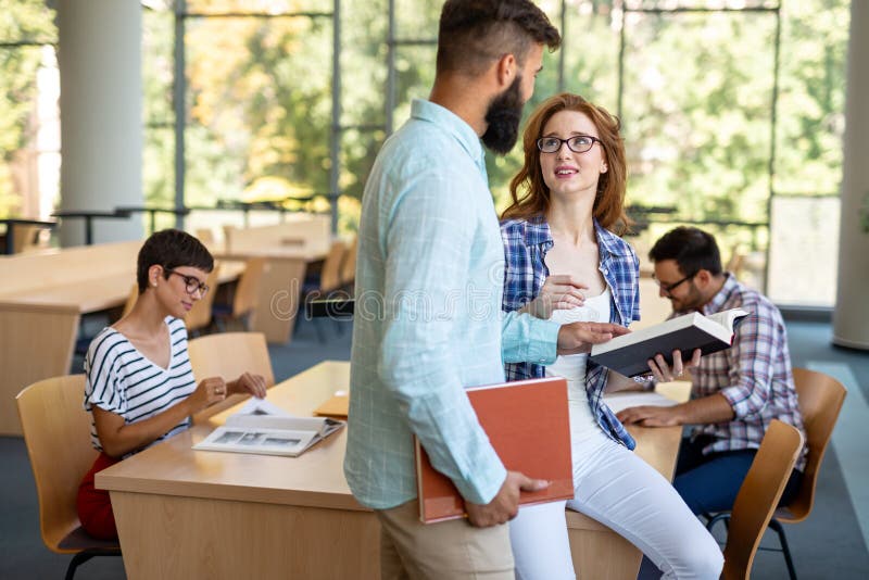 Happy Young University Students Studying with Books in Library. Group ...