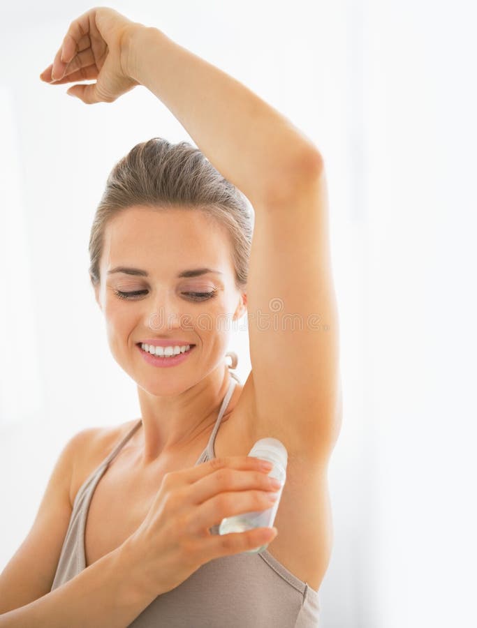 Smiling Woman Applying Roller Deodorant on Underarm in Bathroom Stock ...