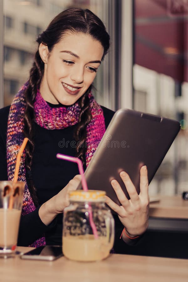Happy Young Woman Drinking Coffee and Using Tablet in a Coffee Stock ...