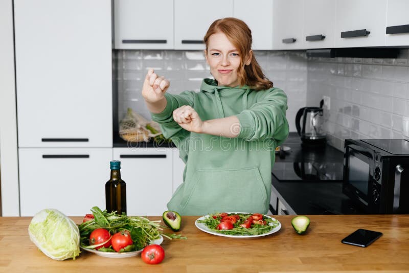 A Happy Young Woman Preparing Dinner in the Kitchen and Dancing Looking ...