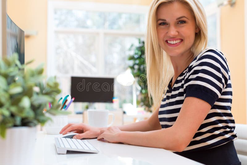 Happy Young Woman Sitting at Her Desk Stock Photo - Image of ...