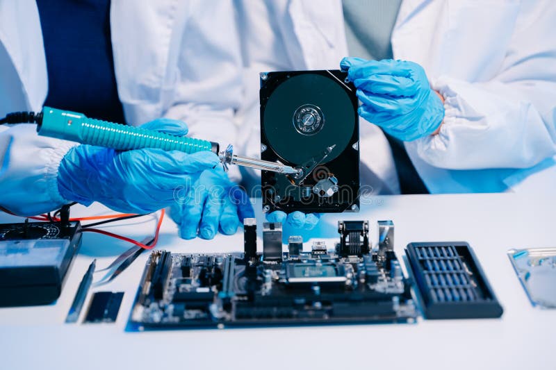 Hard Disk Drive on the Technician S Desk and a Computer Motherboard As ...