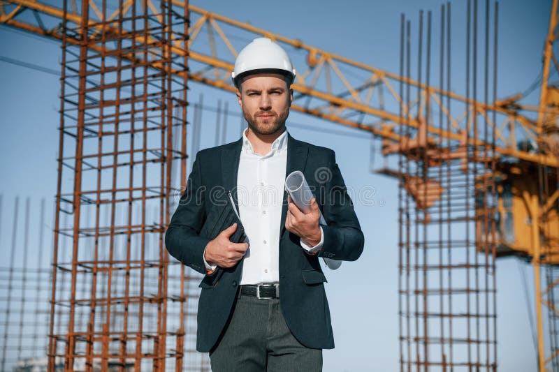 With Plan in Hands. Man in Uniform is Working on the Construction Site ...