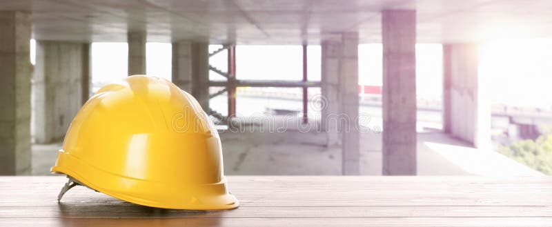 Hard Hat on White Surface at Construction Site with Unfinished Building ...