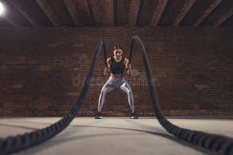 Young Caucasian Woman Working Out with Battle Ropes at a Gym Stock ...