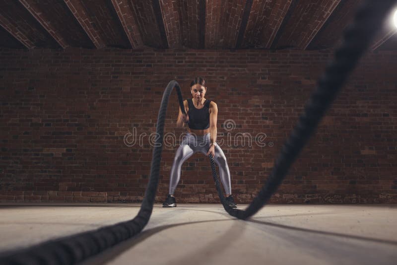 Young Caucasian Woman Working Out with Battle Ropes at a Gym Stock ...