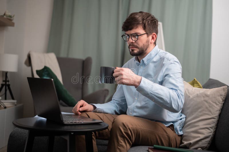 Hard Work with the Help of a Young Man& X27;s Laptop, he Sits on the ...