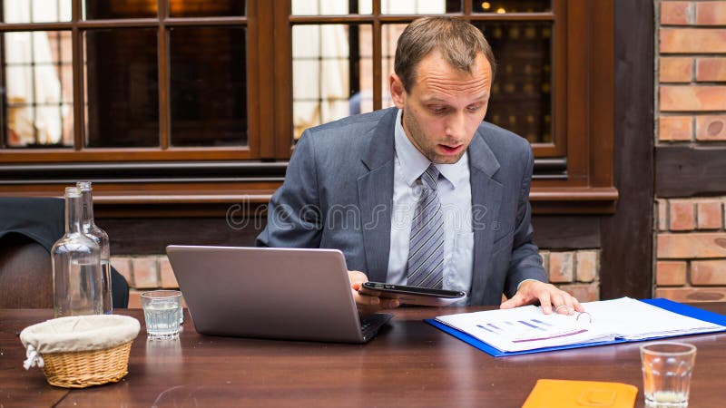 Hard Working Businessman in Restaurant with Laptop and Pad. Stock Photo ...
