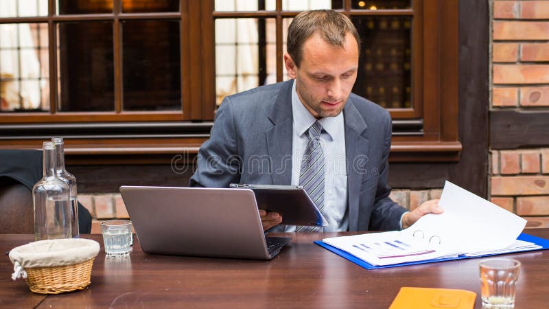 Hard Working Businessman in Restaurant with Laptop and Pad. Stock Photo ...