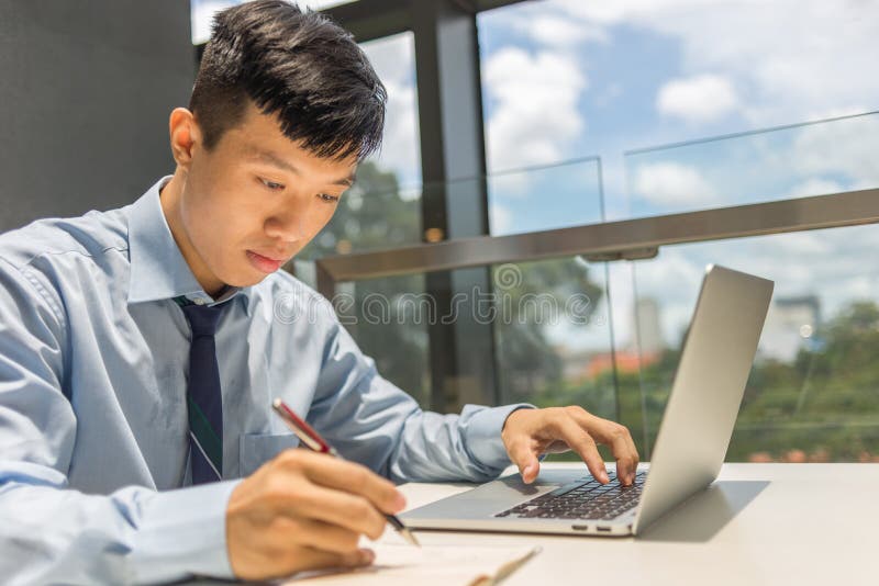 Hard Working Businessman Using Laptop and Writing Notes Stock Photo ...