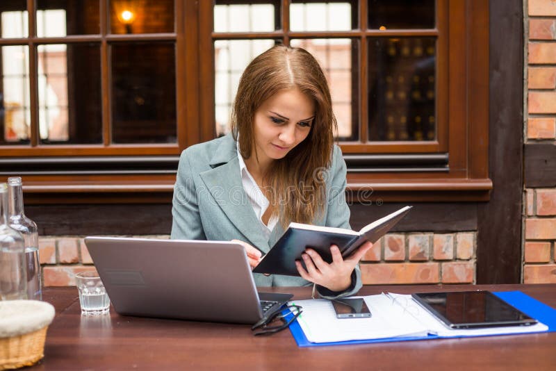 Hard Working Businesswoman in Restaurant with Laptop and Notebook ...
