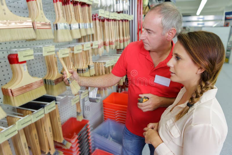 Hardware Store Worker Helping Female Customer Choose Correct Paint ...