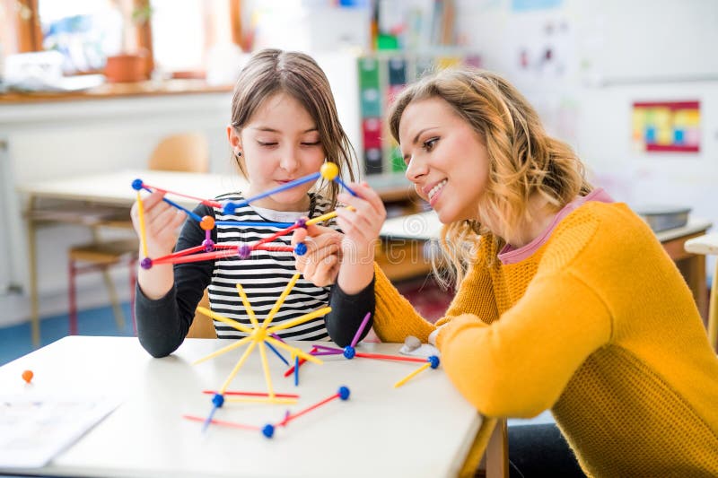 Hardworking Teacher Learning with Young Schoolgirl in Classroom ...