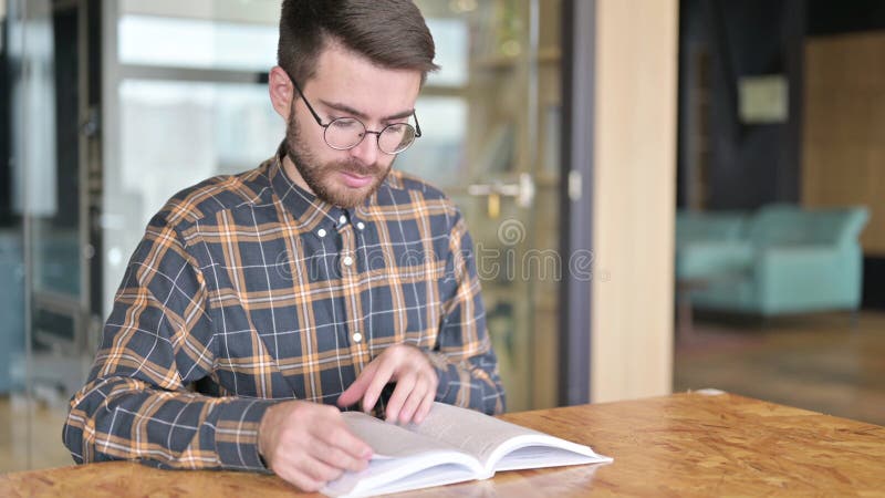The Hardworking Young Designer Reading Book in Office Stock Photo ...