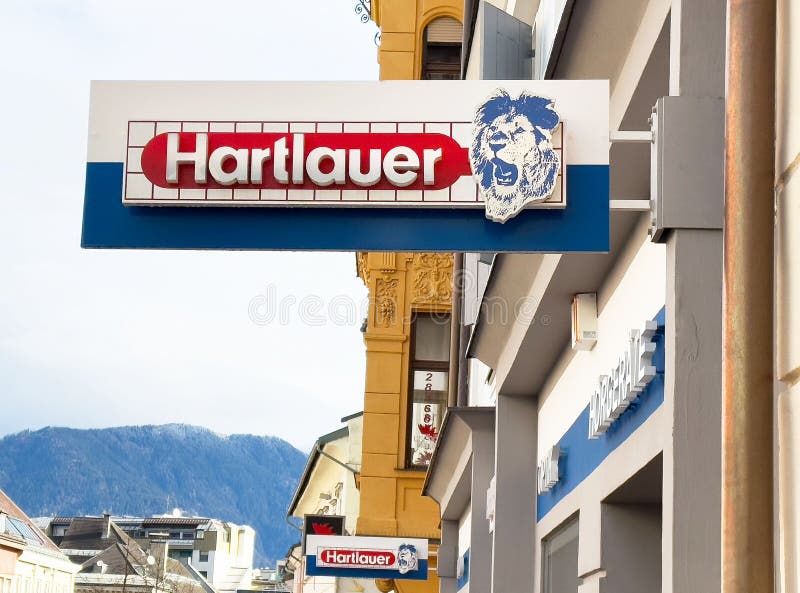 Hartlauer Storefront Sign on Urban Street with Mountain View in Villach ...