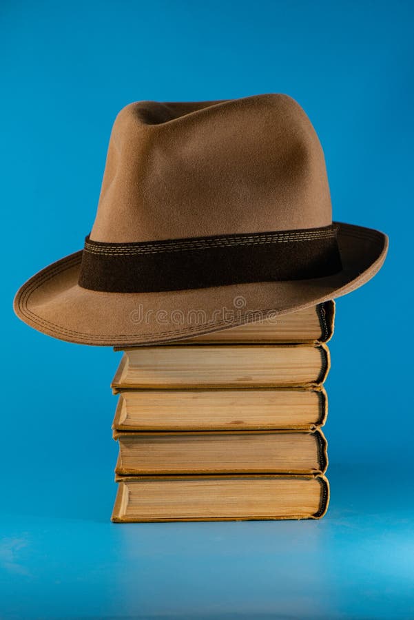 Hat Lies on a Stack of Books, Blue Background Stock Photo - Image of ...