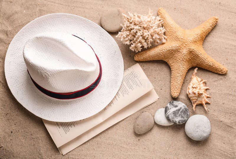 Hat with Sea Shells, Starfish and Newspaper on Sand Stock Photo - Image ...
