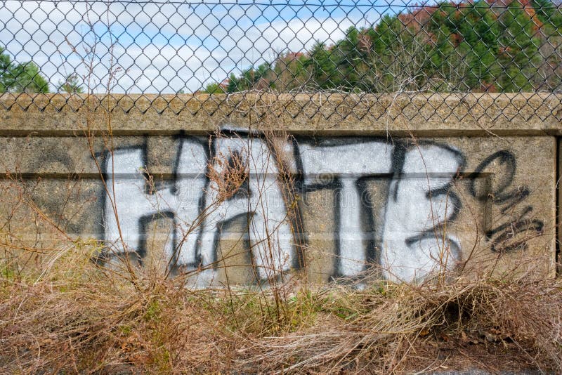 `Hate` Graffiti Painted on Cement Wall in Large White Capital Letters ...