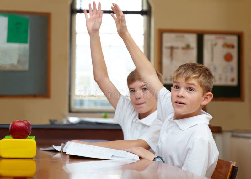 We Have the Answer. Two Young Schoolboys Raising Their Hands in a ...