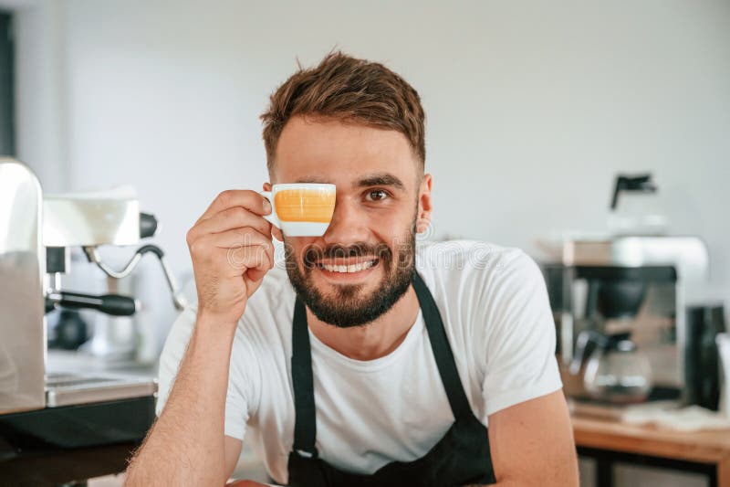 Having Fun with Cup. Cafe Worker in White Shirt and Black Apron is ...