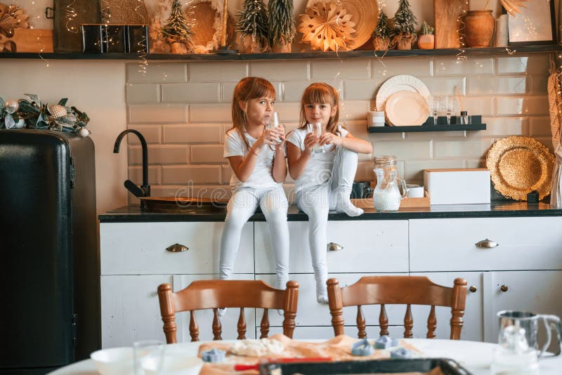 Having Fun. Happy Two Little Girls are Drinking Milk while Sitting on ...