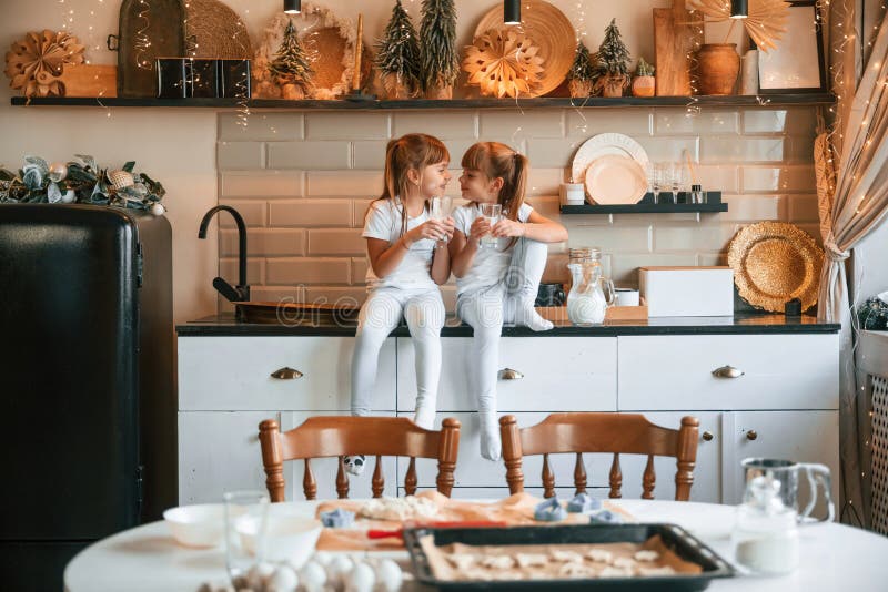 Having Fun. Happy Two Little Girls are Drinking Milk while Sitting on ...