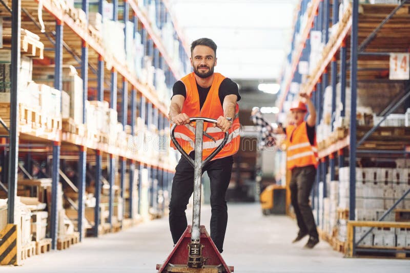 Having Fun by Using Trolley Platform. Two Storage Workers is in the ...