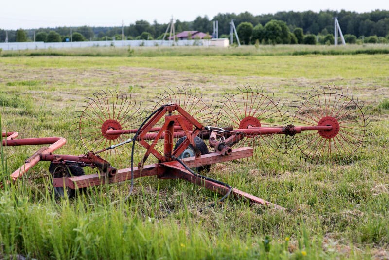 Hay tedder on the field stock photo. Image of harvest - 119871464