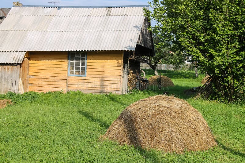 Haystack on Green Lawn in Front of House Stock Photo - Image of ...