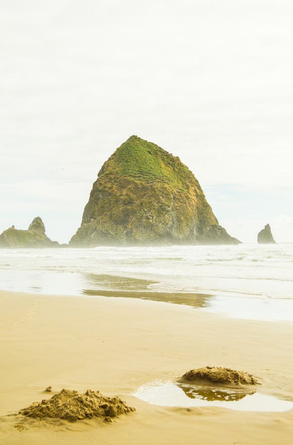 Haystack Rock in the mist stock photo. Image of cannon - 55273598