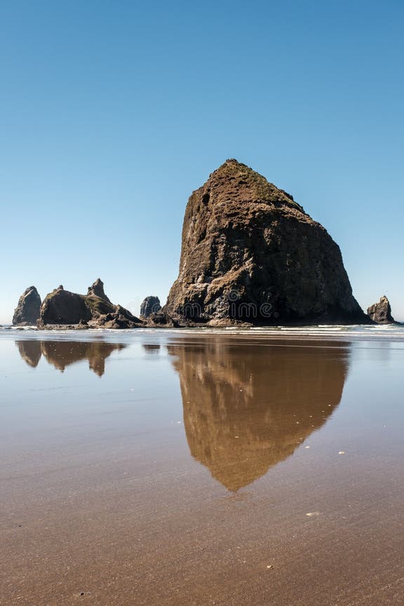 Haystack Rock Reflection in the Water Along the Beach in Oregon Stock ...