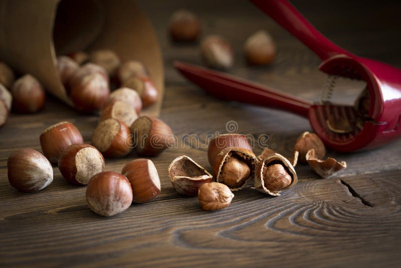 Hazelnuts with a Red Nutcracker on a Wooden Board. Nuts in Craft Paper ...