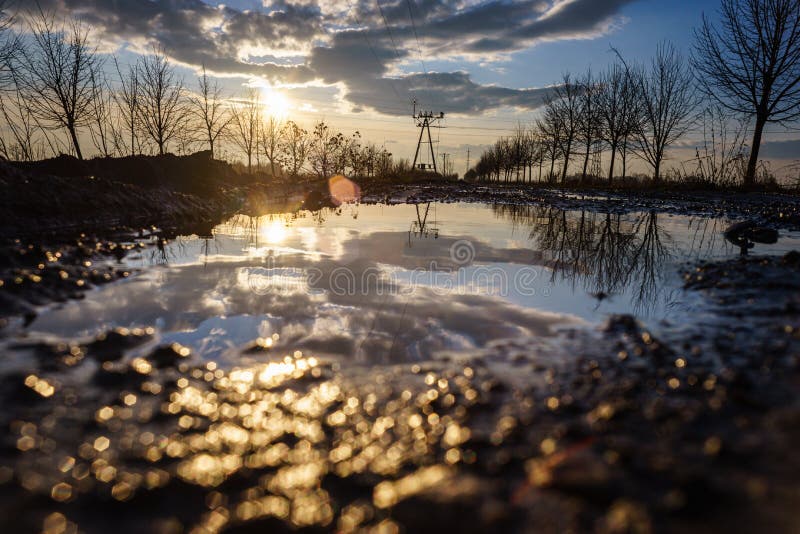 HDR Photo of the Setting Sun Reflecting in a Puddle. Stock Photo ...
