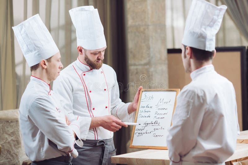 Head Chef and His Staff in Kitchen. Interacting To in Commercial ...